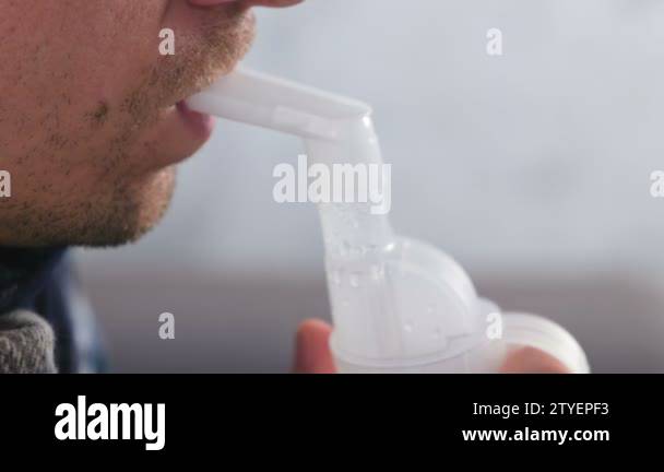 Use nebulizer and inhaler for the treatment. Sick man inhaling through ...