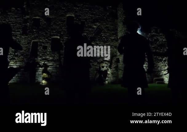 Archers launch fire arrows in the medieval castle at night during the ...