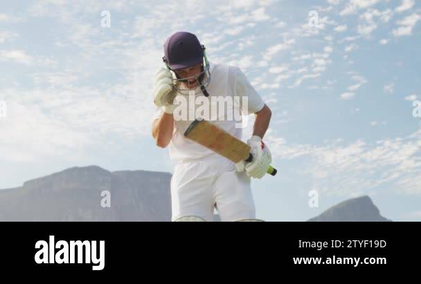 Low angle front view of a teenage Caucasian male cricket player wearing ...