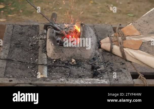 Blacksmiths working old fashioned bellows at the forge. The blacksmith ...