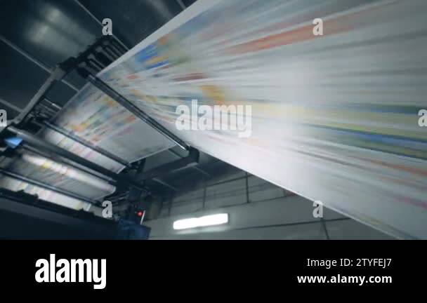 Printed newspaper going on a rolling conveyor, print office equipment ...