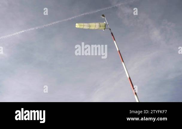 Windsock on sunset sky background. Gauge weather instrument blazing in ...