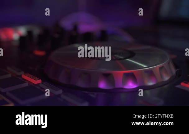 DJ controller for mixing music on night party and colorful light in ...