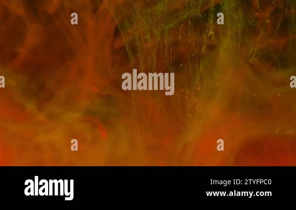 Red and yellow color paint inks explosion in water in slow motion on ...