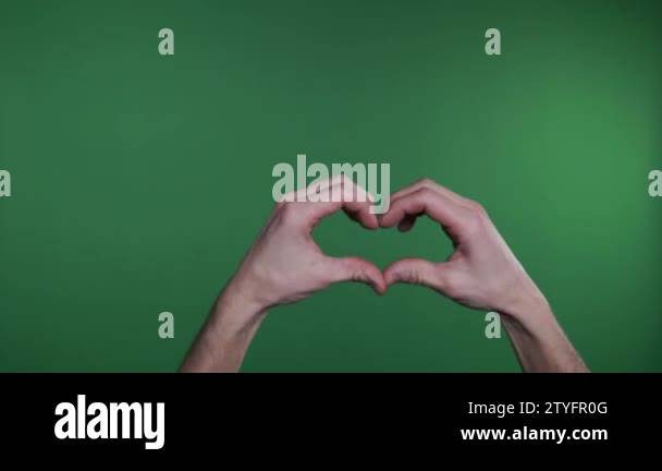 Romantic Love Sign With Hands On Green Screen. Hands making a love sign ...
