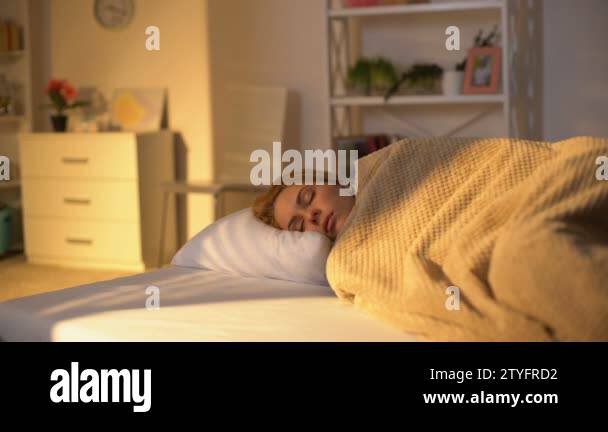 Tired female sleeping in bed, daytime nap, weekend laziness, home ...