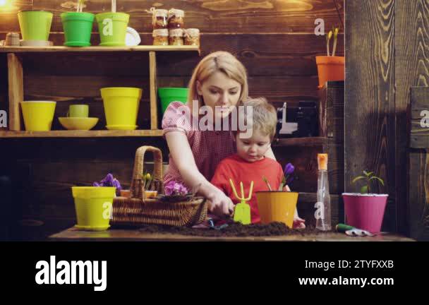 Cute child boy helps his mother to care for plants. Mother and her son ...