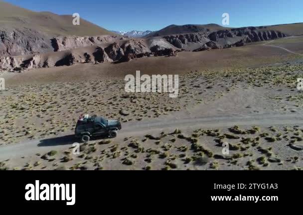 Aerial drone scene of 4x4 van driving at track off road at golden ...