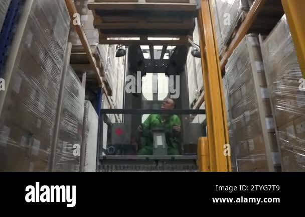 Warehouse man worker with forklift. loader loading goods at shelves ...
