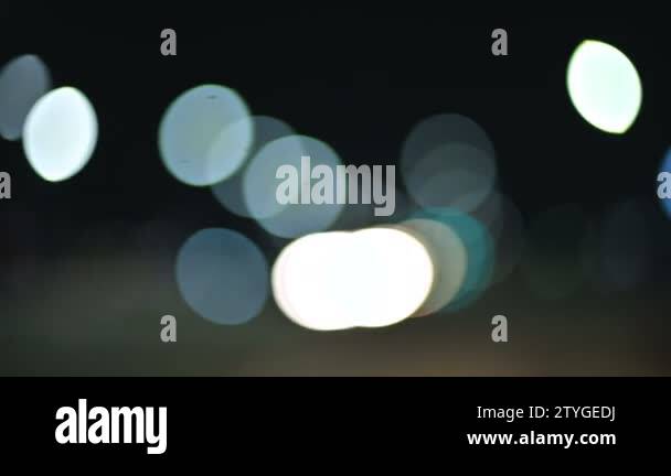 Colored bokeh lights in the night country road. moving circles of ...
