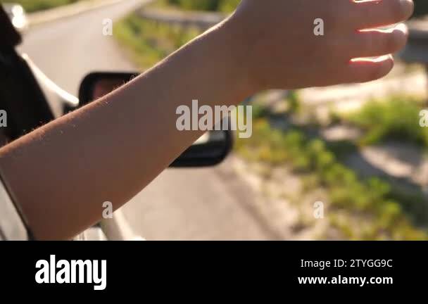 woman traveler rides by car. a hand from the car window catches the ...