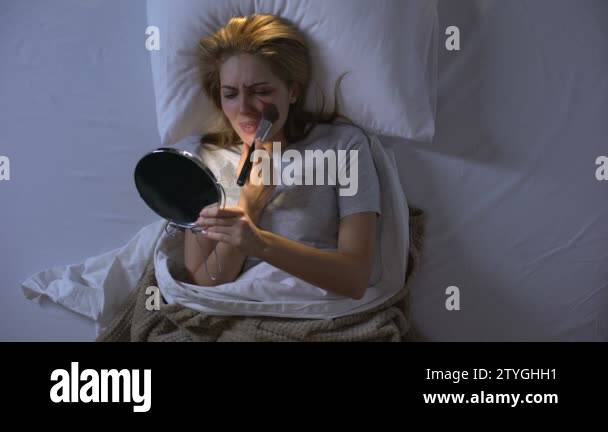 Female victim trying to cover wound on face with powder, crying ...