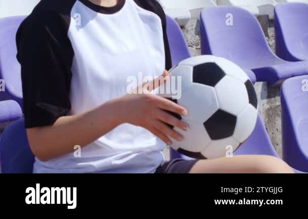 Young woman footballer seating with a football soccer ball on the ...