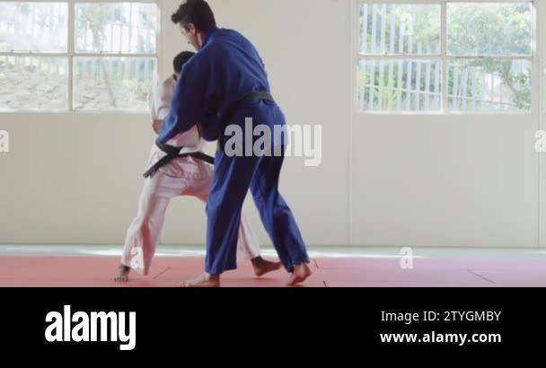 Side view of a mixed race male judo coach and teenage mixed race male ...
