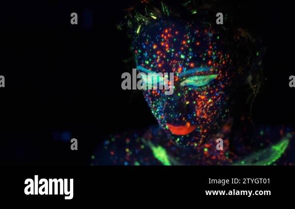 girls face in neon light. portrait of a young woman colored with ...