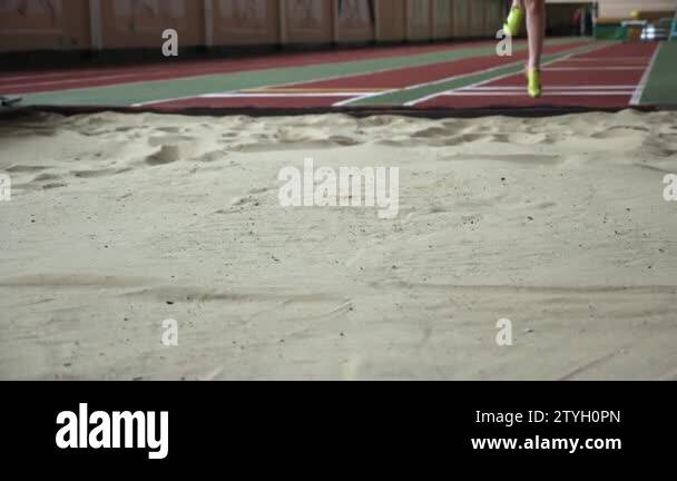 Girl athlete performing long jump into sandbox Stock Video Footage - Alamy