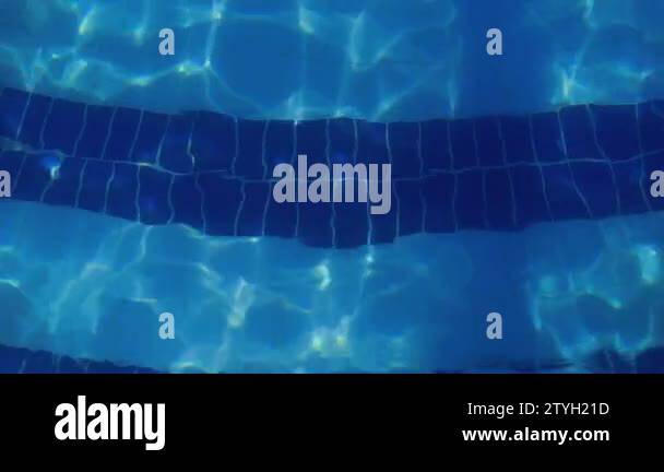 Moving water in the swimming pool shines on the sunset, blue ...