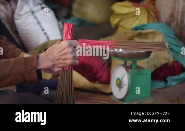 Vietnamese woman weighs, packs and puts out newly made incense sticks ...