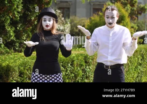 Two young funny mimes behind an invisible glass box or wall. Two mimes ...