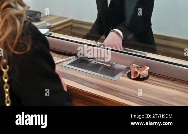 Employee and client count money on a counter at the currency exchange ...
