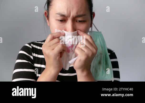 Asian young woman coughing up blood in a tissue paper feel sick at ...