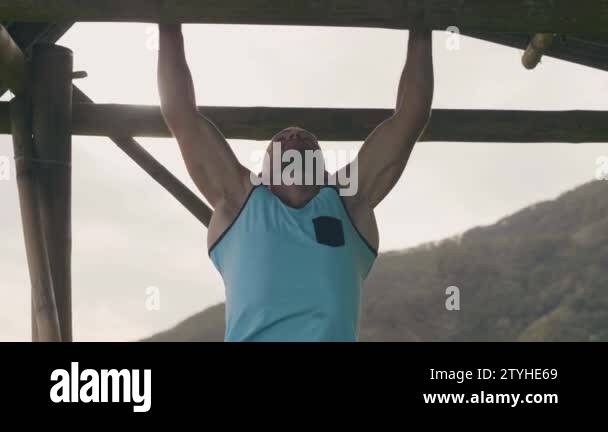 Athlete man pulling on wooden crossbar while workout outdoor ...