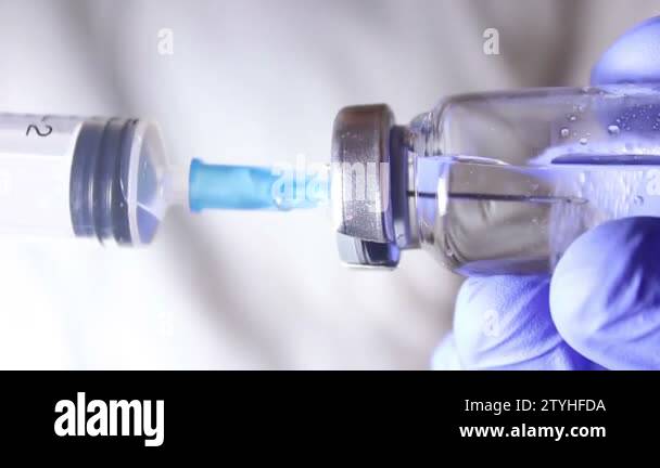 Doctors hands fill the syringe with vaccine, preparing for the ...
