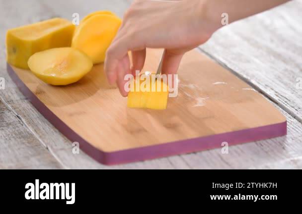 Female Chefs hands cutting mango on wooden cutting board Stock Video ...
