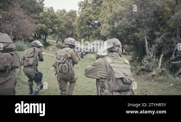 Squad of fully armed commando soldiers during combat in a forest ...