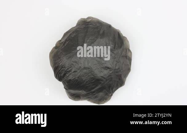 crumpled into a ball used black plastic bag rotates on white background ...