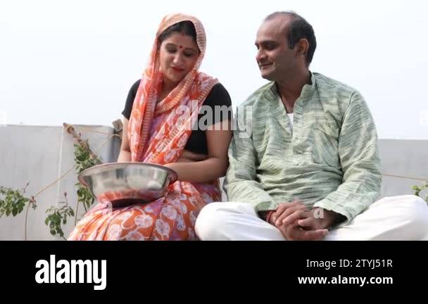 Lower middle class couple happily talking along the with wife doing her ...