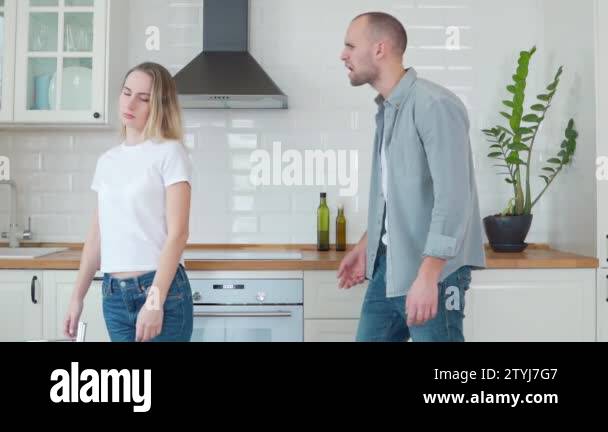 Aggressive man arguing with wife at luxury kitchen. Angry husband ...