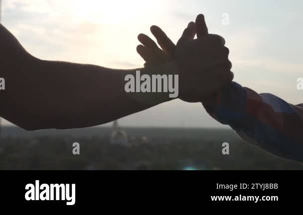 Friendly handshake of two unrecognizable men on cityscape background ...