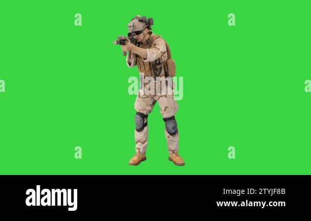 Army soldier standing his ground aiming with assault rifle on a Green ...