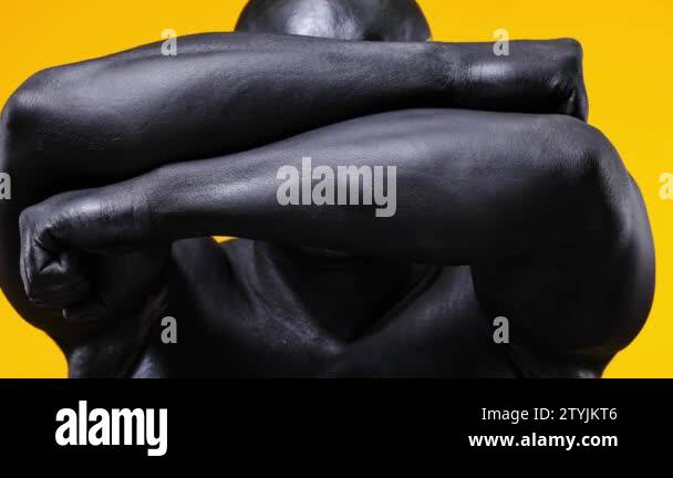 Man bodybuilder athlete with yellow color on face art and black body ...