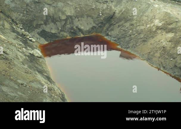 Throwing stone into the petroleum lagoon water. the former dump toxic ...