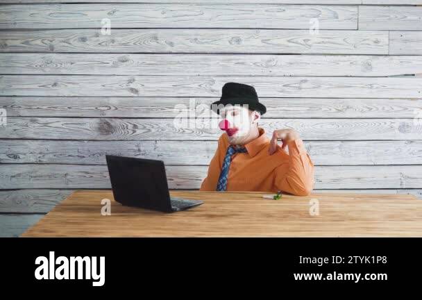 Office worker clown, clown concept at work. Businessman at the computer ...