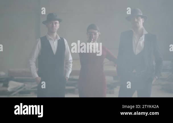 Two confident well-dressed men standing in two sides of a woman in red ...