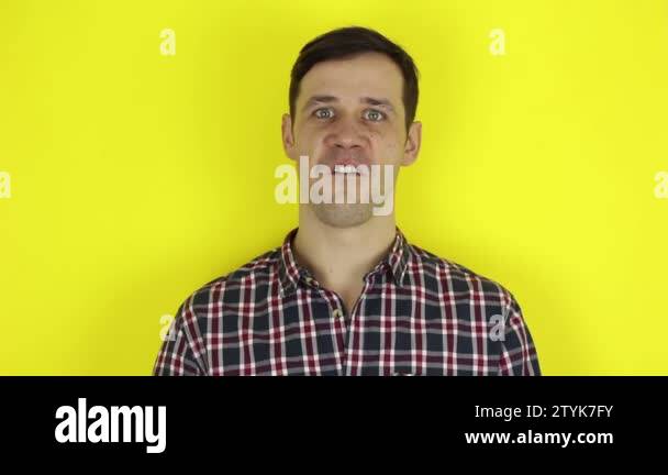 A funny, handsome guy shows indecent hand gestures. Portrait of a young ...