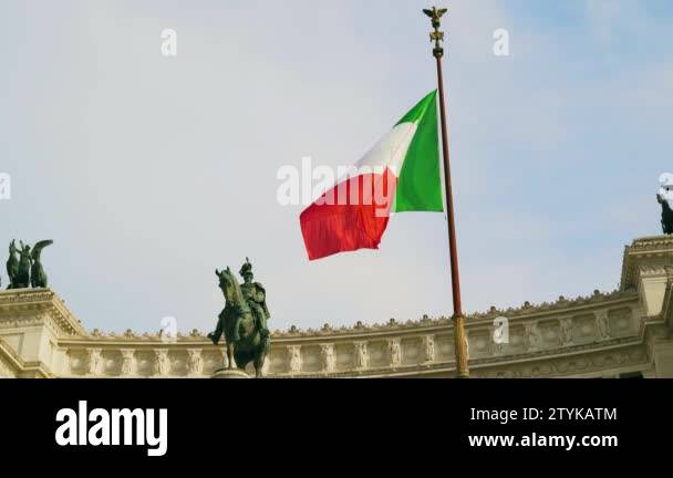 Italian flag waving against the equestrian statue representing the ...