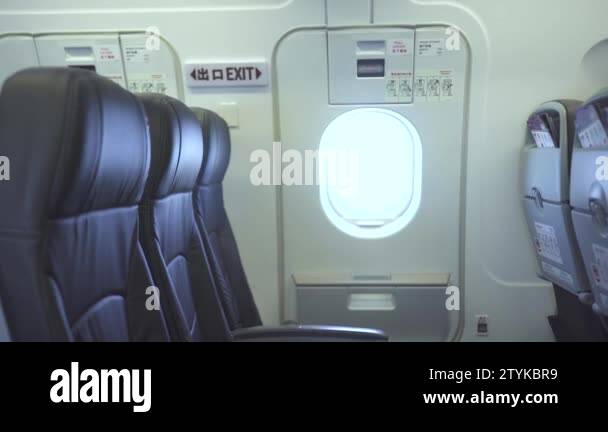 Passenger seats and emergency exit door inside commercial airplane ...