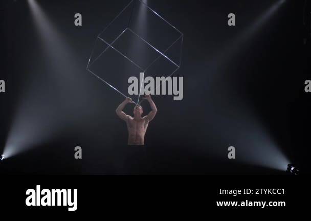 circus male muscular performer making tricks with juggling cube props ...