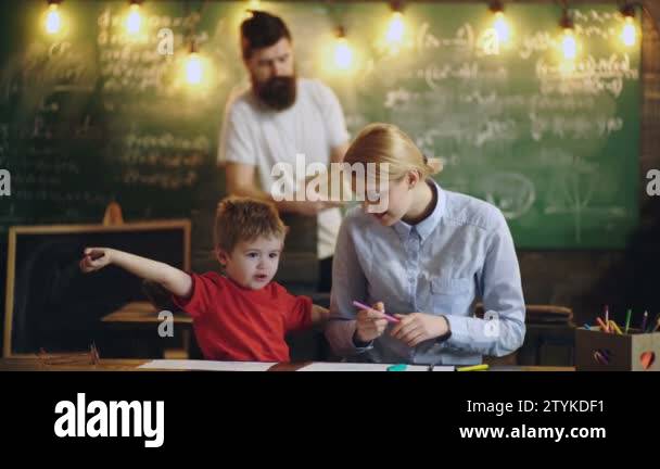 Friendly teachers and child boy are drawing in classroom. Teacher ...