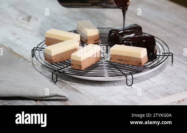 The chocolate icing on the froasted cake.Modern French mousse cake with ...