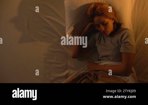 Lonely woman waking up and stroking sheet, remembering her husband ...