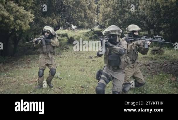 Squad of fully armed commando soldiers during combat in a forest ...