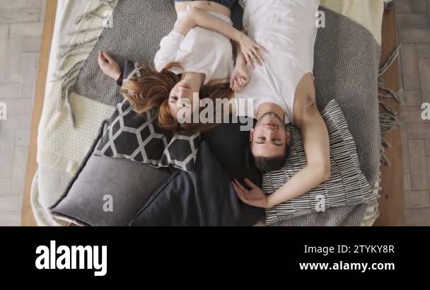 Loving young couple lying in bed together hugging and sleeping, top ...