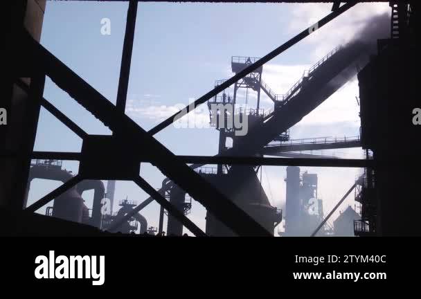 Old factory smoke stack billowing a white gray plume across blue sky ...