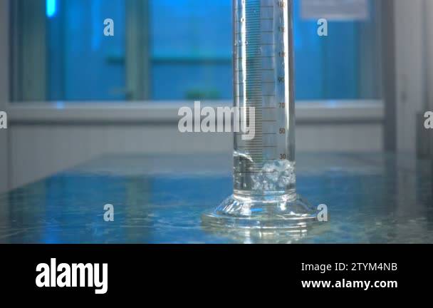 Fill the flask with water. Measure the volume of the solution. Close-up ...