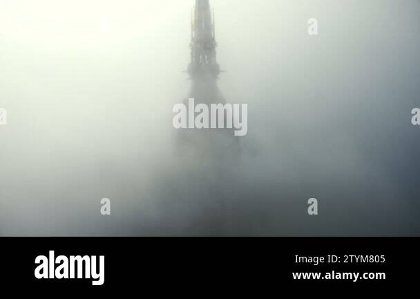 Drone rising above foggy clouds to reveal epic golden statue on top of ...